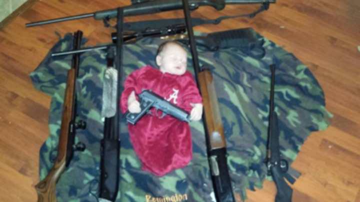 Alabama Fan Puts Baby in Crimson Tide Onesie, Surrounds Baby with Guns